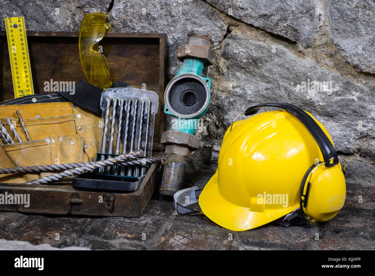 Construction tools for building a house on a stone wall. Hammer, helmet ...
