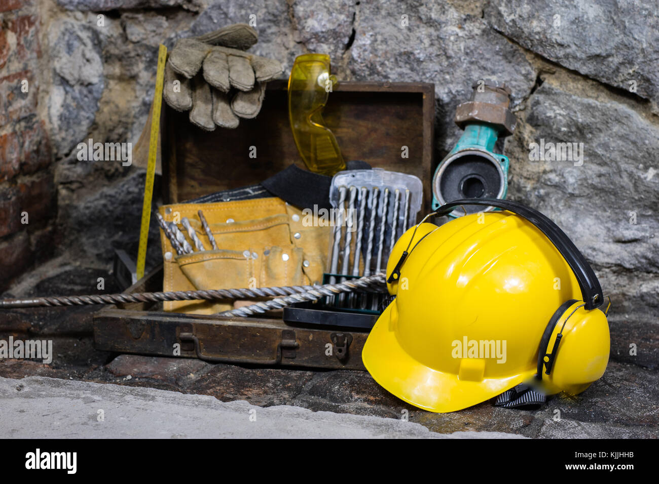 Construction tools for building a house on a stone wall. Hammer, helmet ...