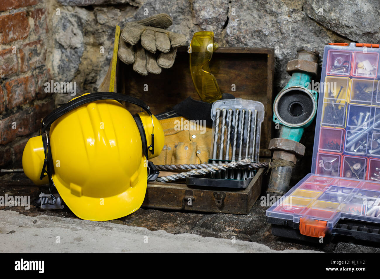 Construction tools for building a house on a stone wall. Hammer, helmet ...