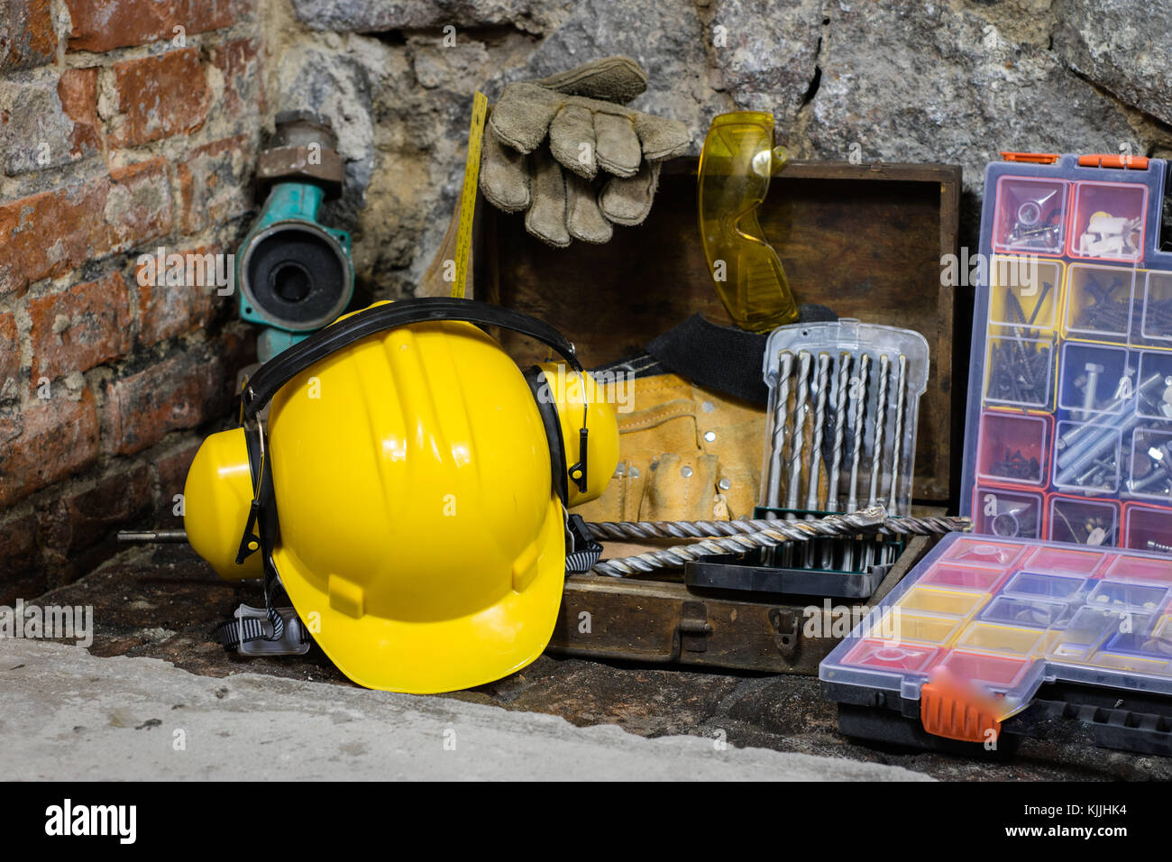 Construction tools for building a house on a stone wall. Hammer, helmet ...