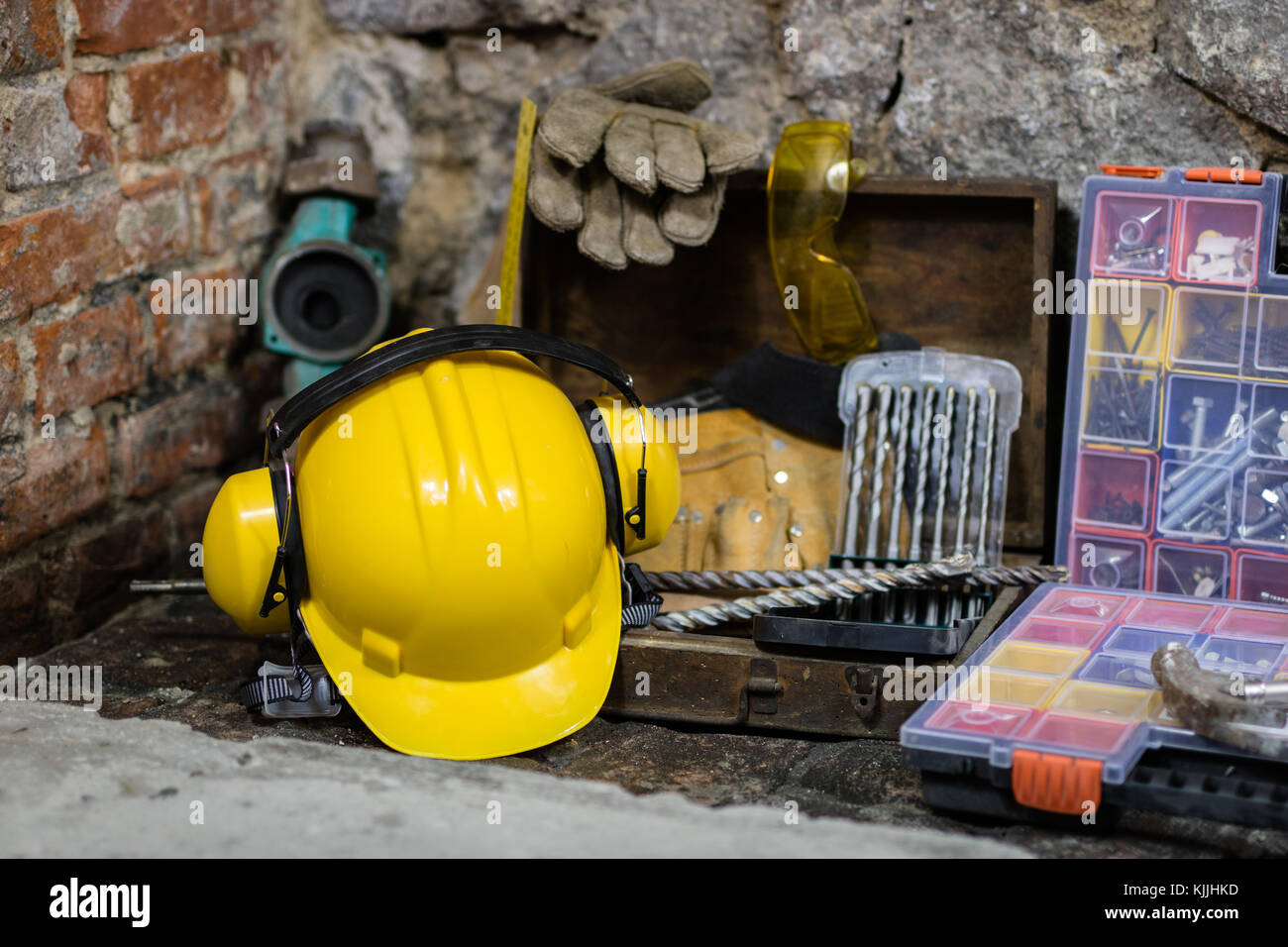 Construction tools for building a house on a stone wall. Hammer, helmet ...