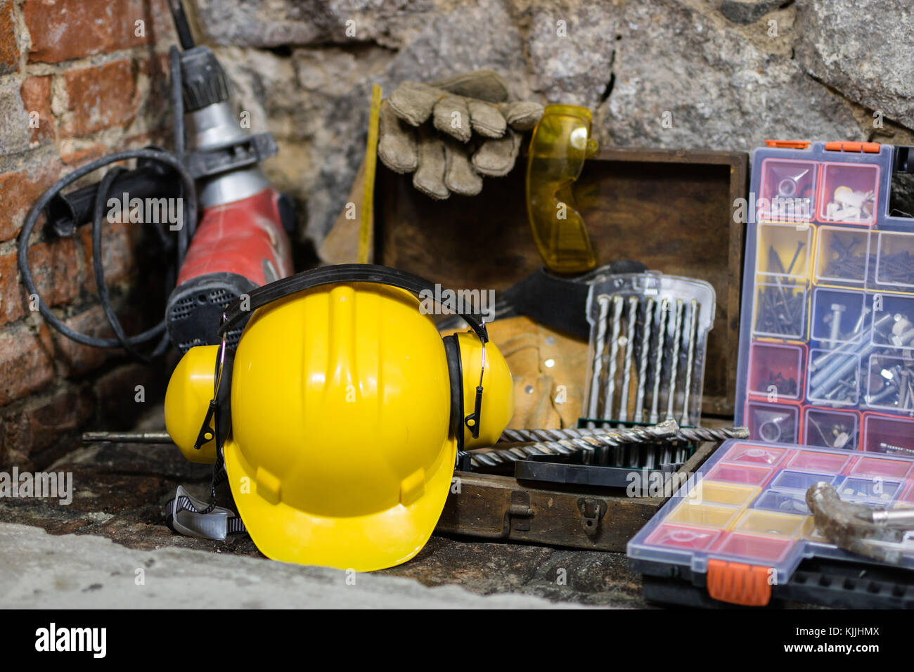 Construction tools for building a house on a stone wall. Hammer, helmet ...