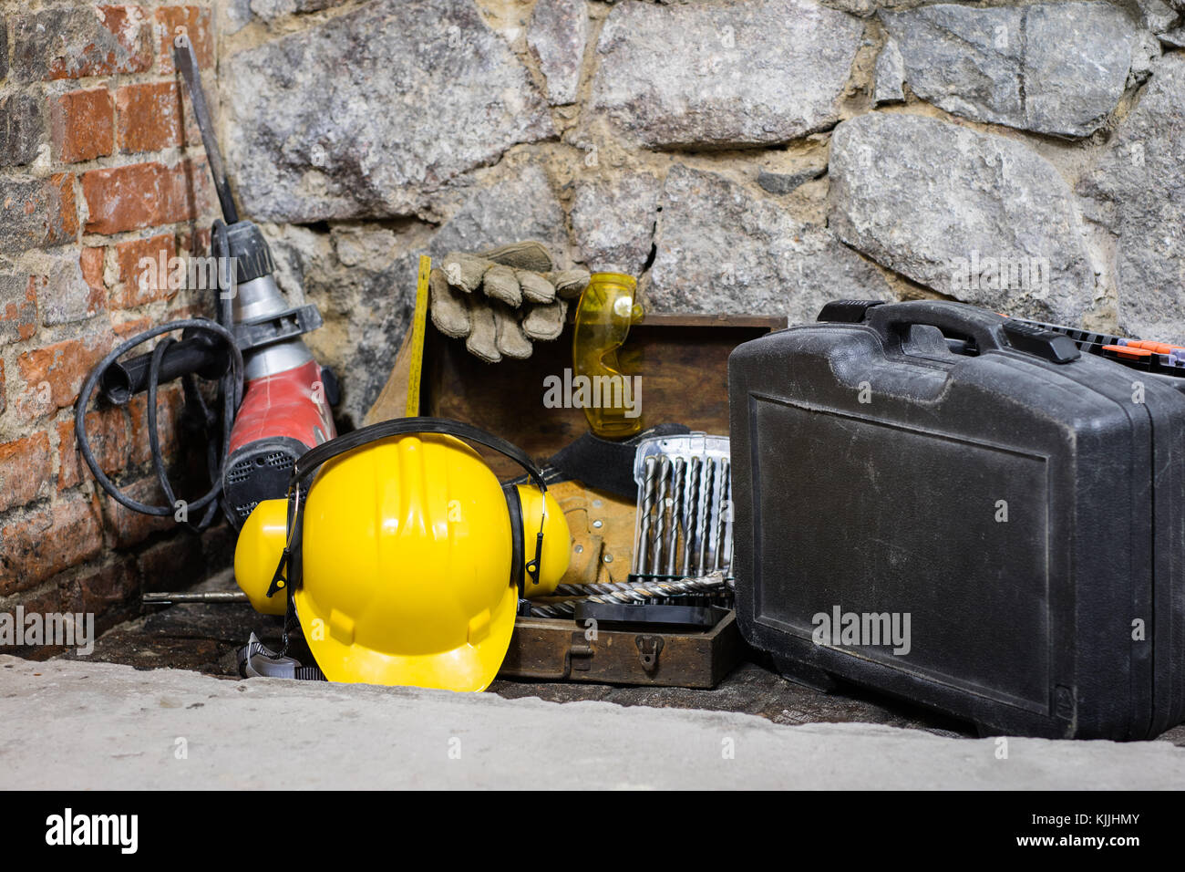 Construction tools for building a house on a stone wall. Hammer, helmet ...