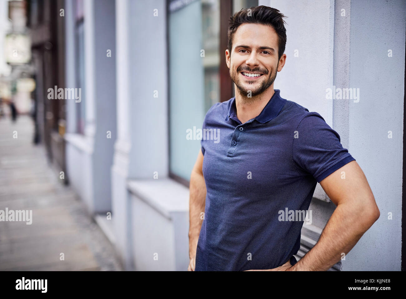Smiling man standing on city street Stock Photo - Alamy