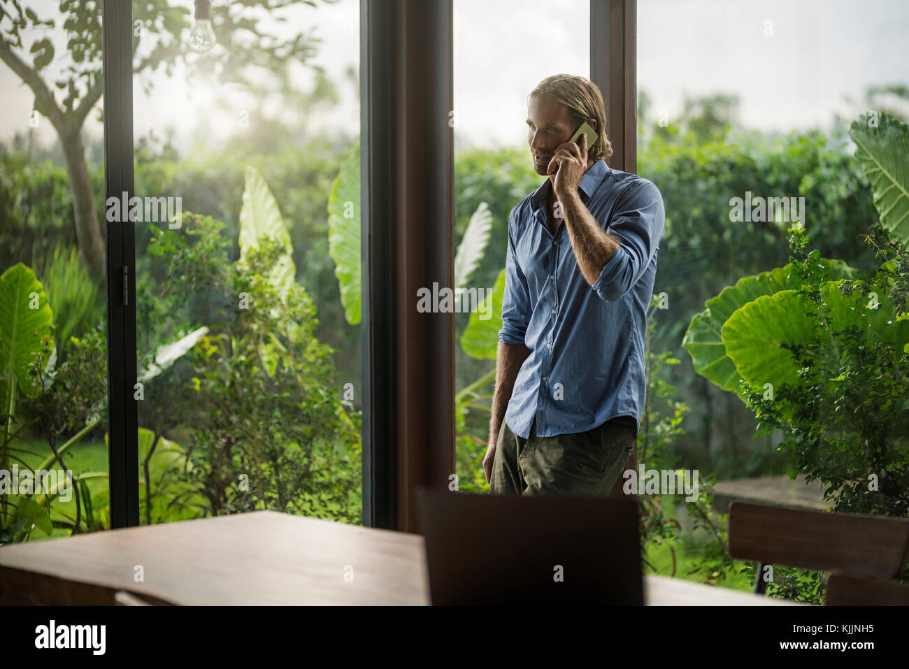 handsome man talking on smartphone in contemporary design house Stock ...