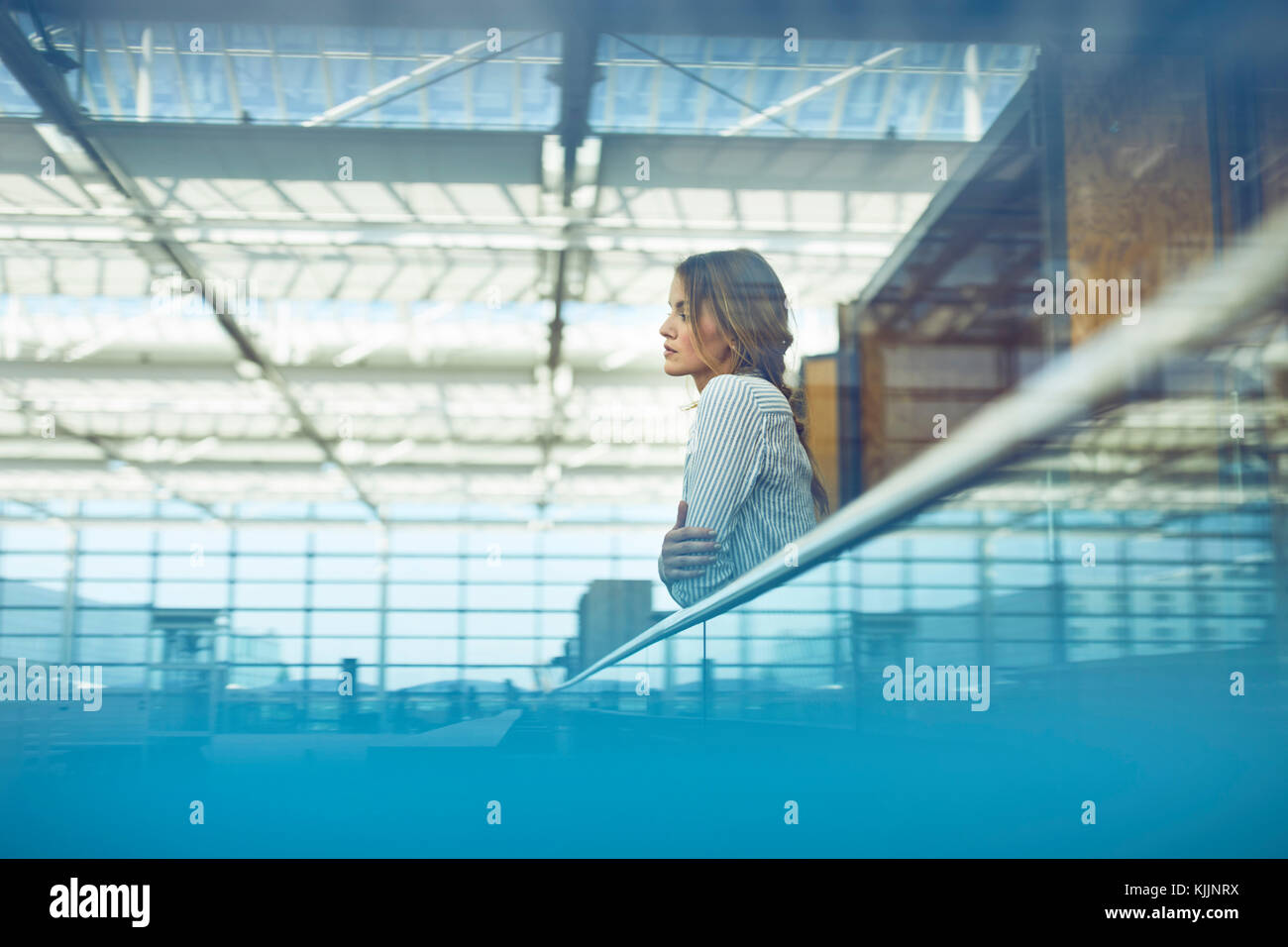 Serious woman leaning on railing Stock Photo - Alamy