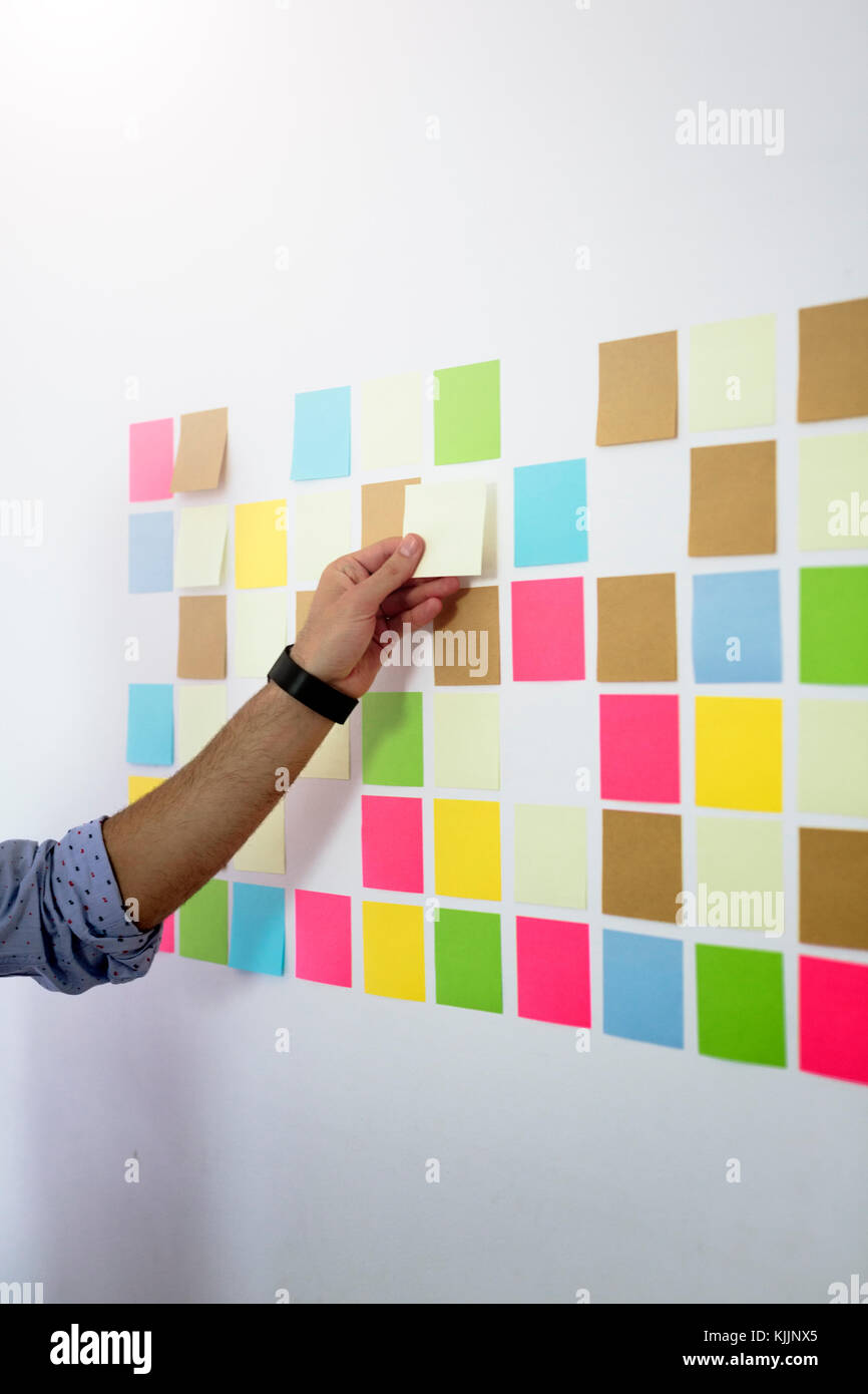 Young businessman working in office with sticky notes on wall Stock ...