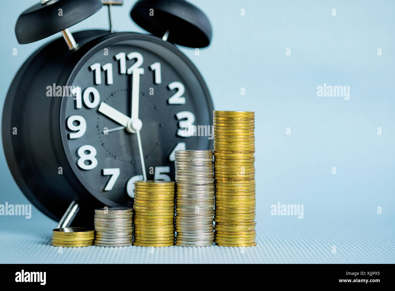 Alarm clock and step of coins stacks, time for savings money concept ...