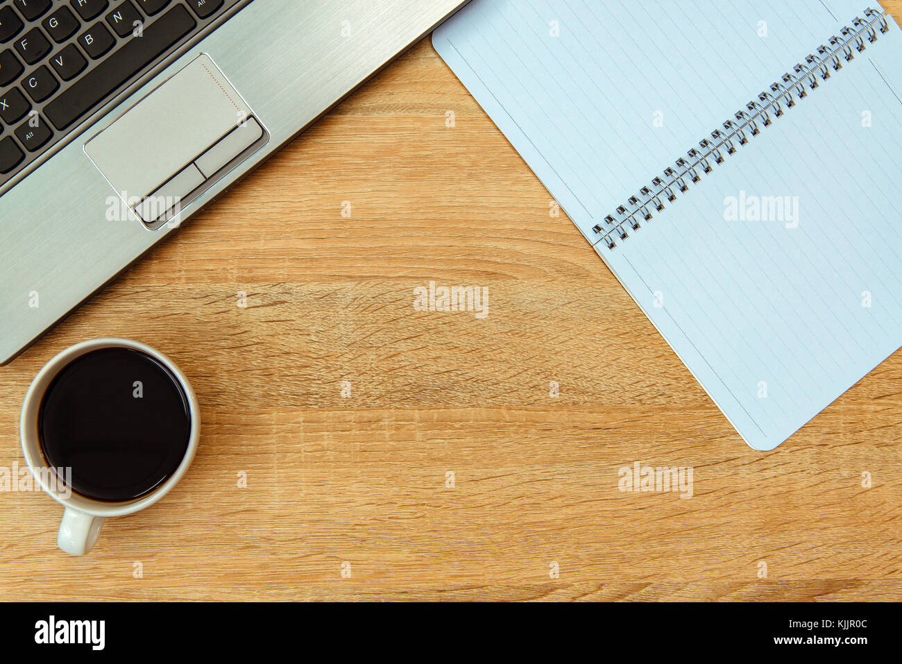 Laptop computer or notebook, note and cup of coffee on working table or ...