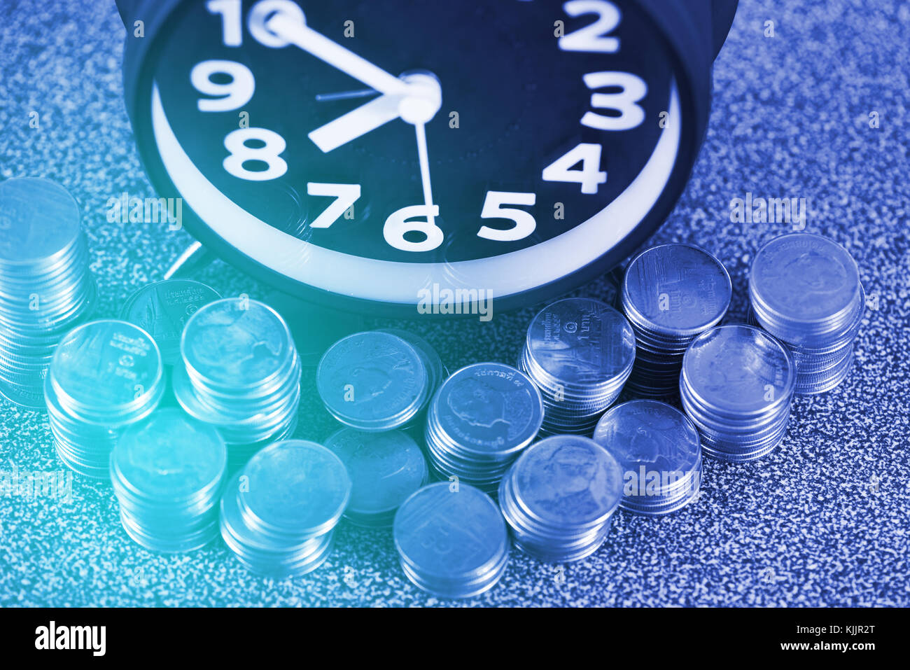 Alarm clock and step of coins stacks on working table, time for savings ...