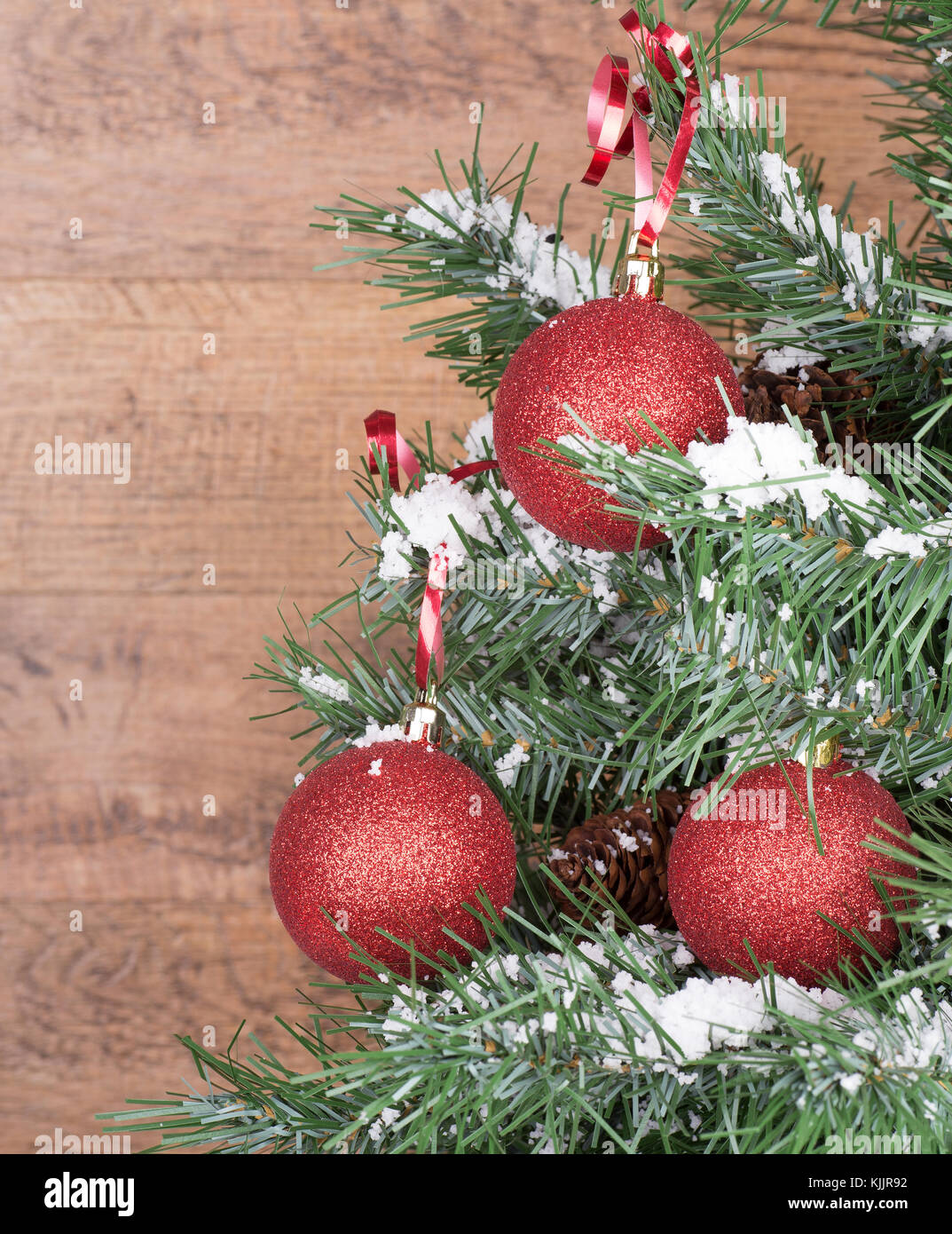 Red Christmas ornaments hanging on a tree with a wood background Stock ...