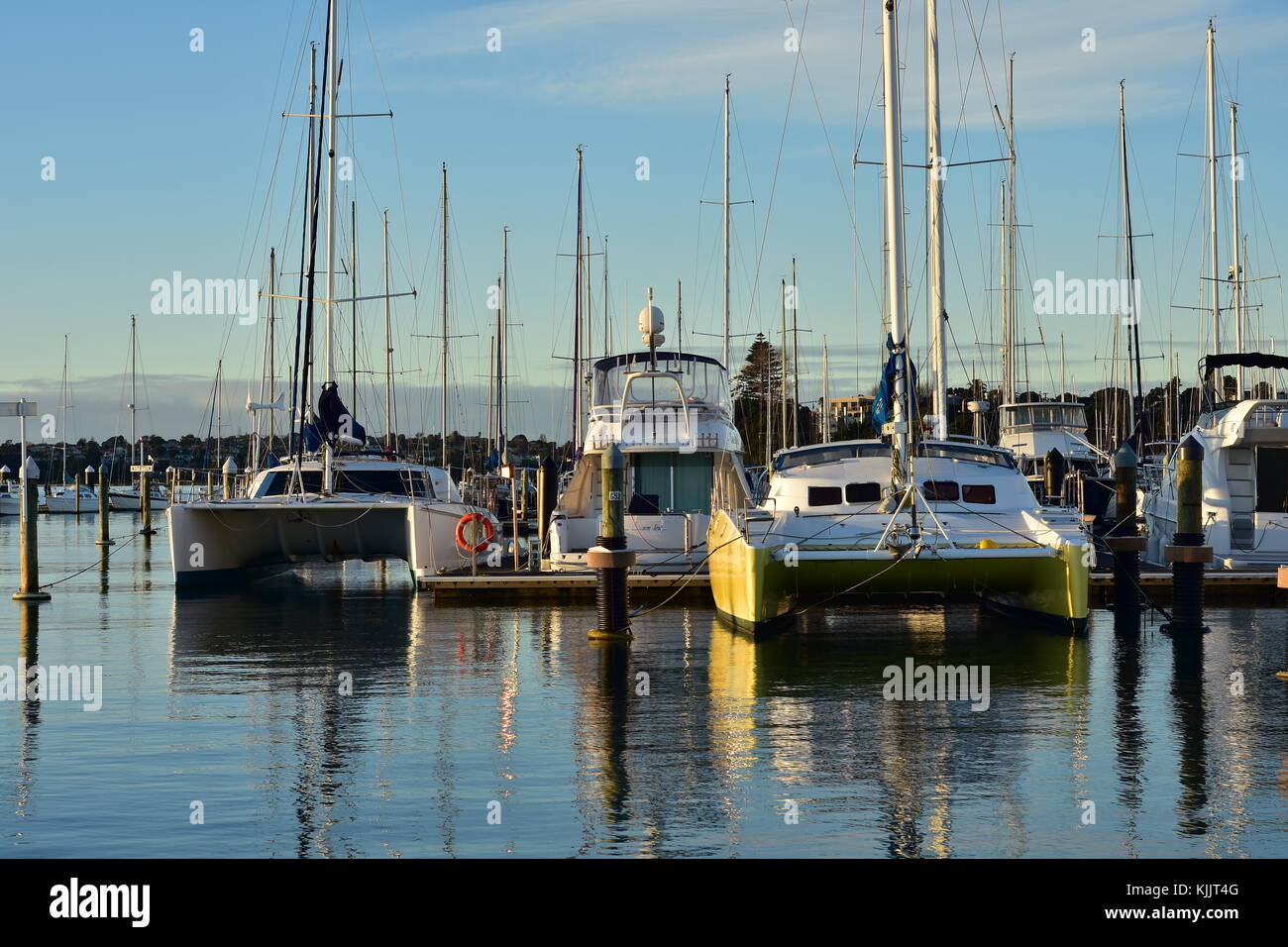 Sailing catamarans and large power boats berthed in marina Stock Photo ...