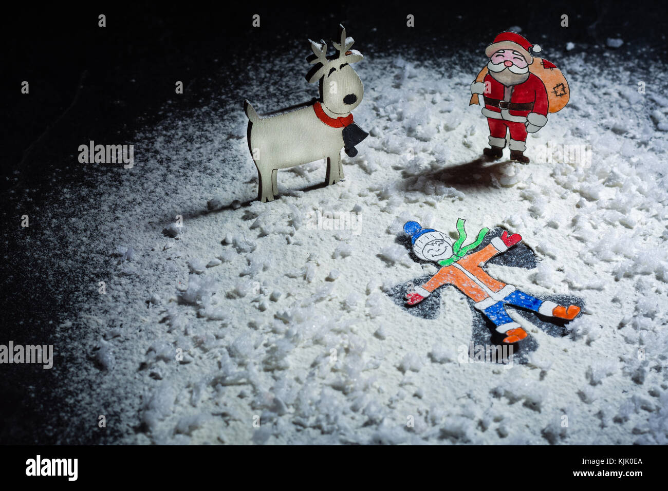 Paper figures of the child as a snow angel Santa Claus and deer. Hand ...