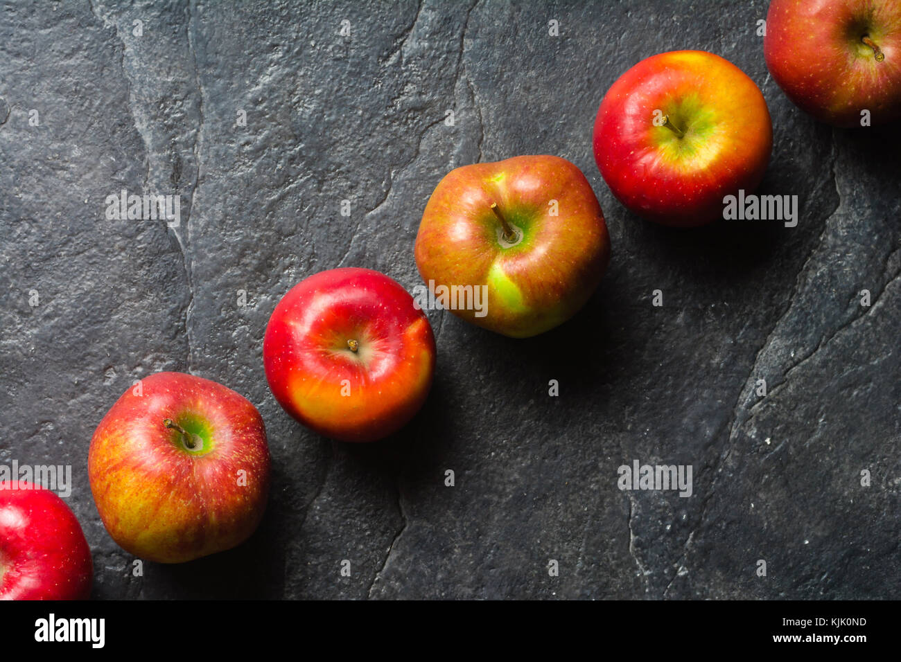 Ripe autumn apples red and yellow on a black stone background from ...