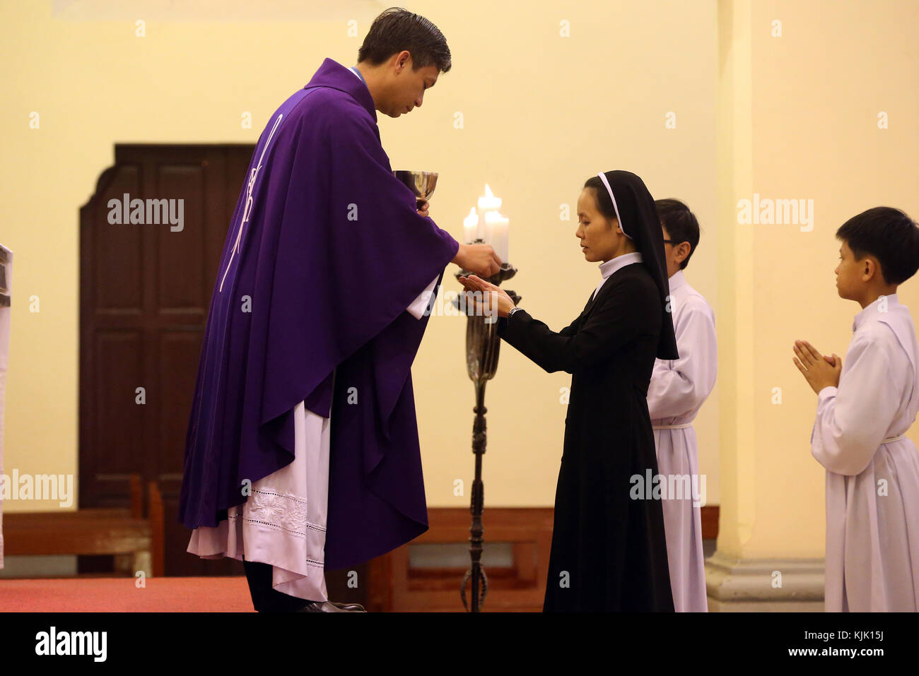Dalat cathedral. Catholic mass. Catholic priest giving Holy Communion ...