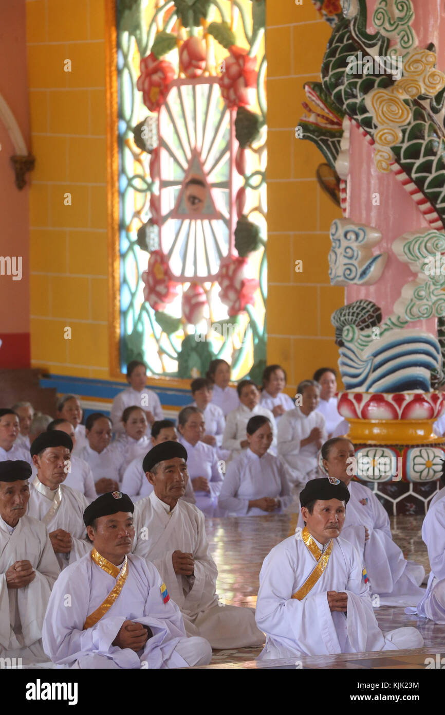 Cao Dai Holy See Temple. Praying devout men, ceremonial midday prayer ...