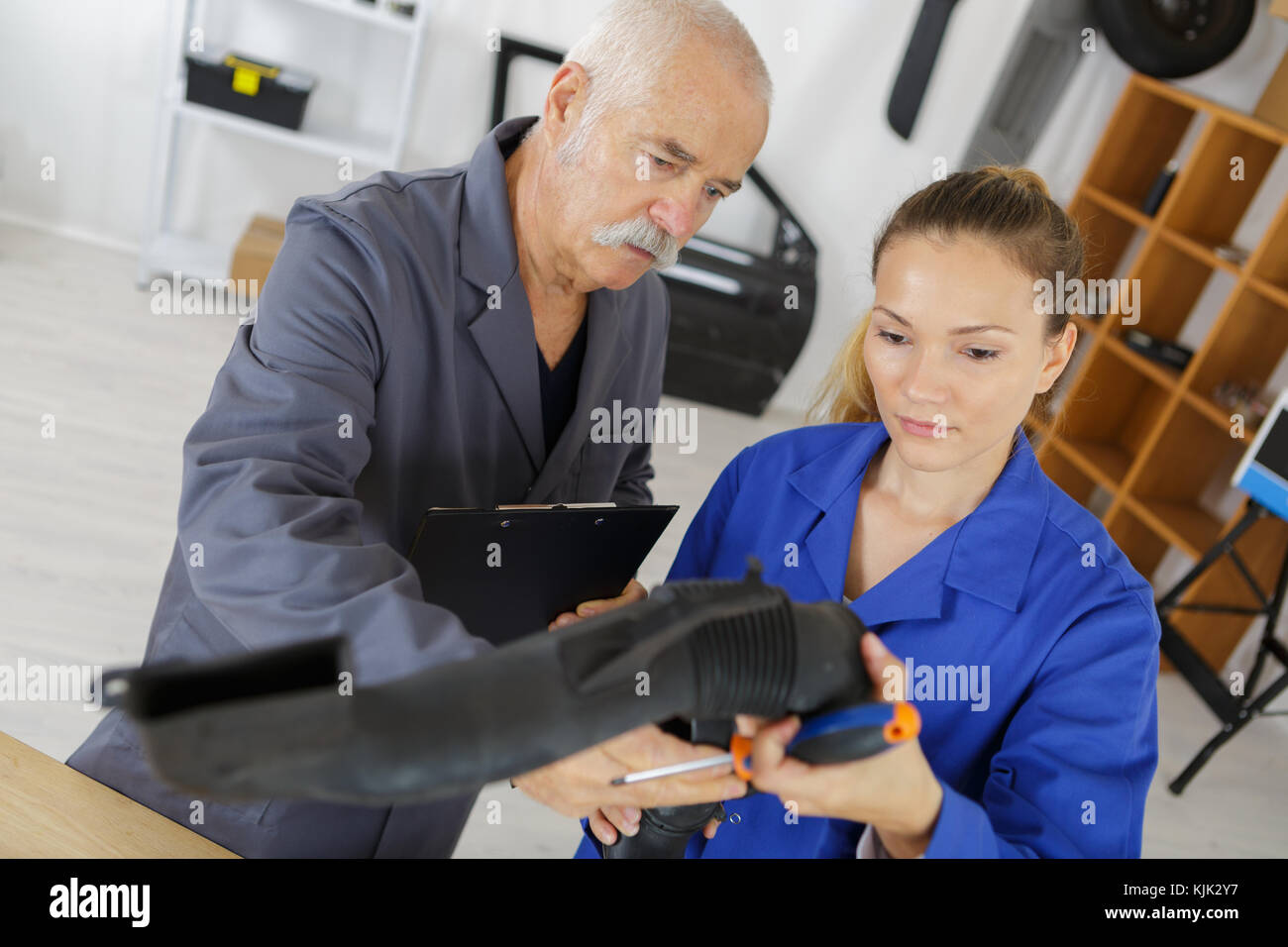 Female apprentice holding mechanical part Stock Photo - Alamy