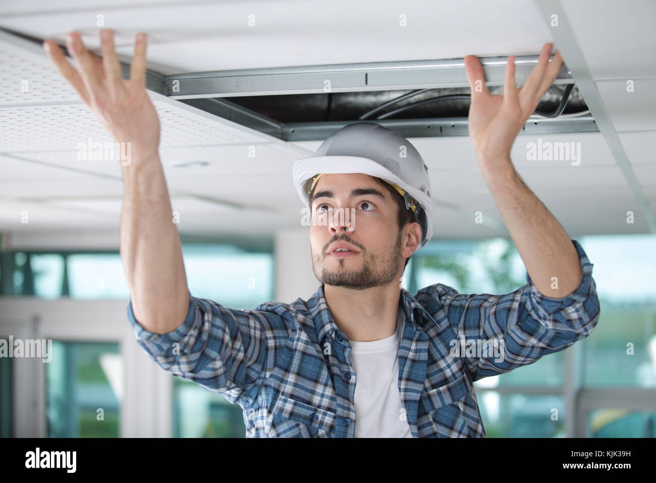 male contractor fitting ceiling panel Stock Photo - Alamy