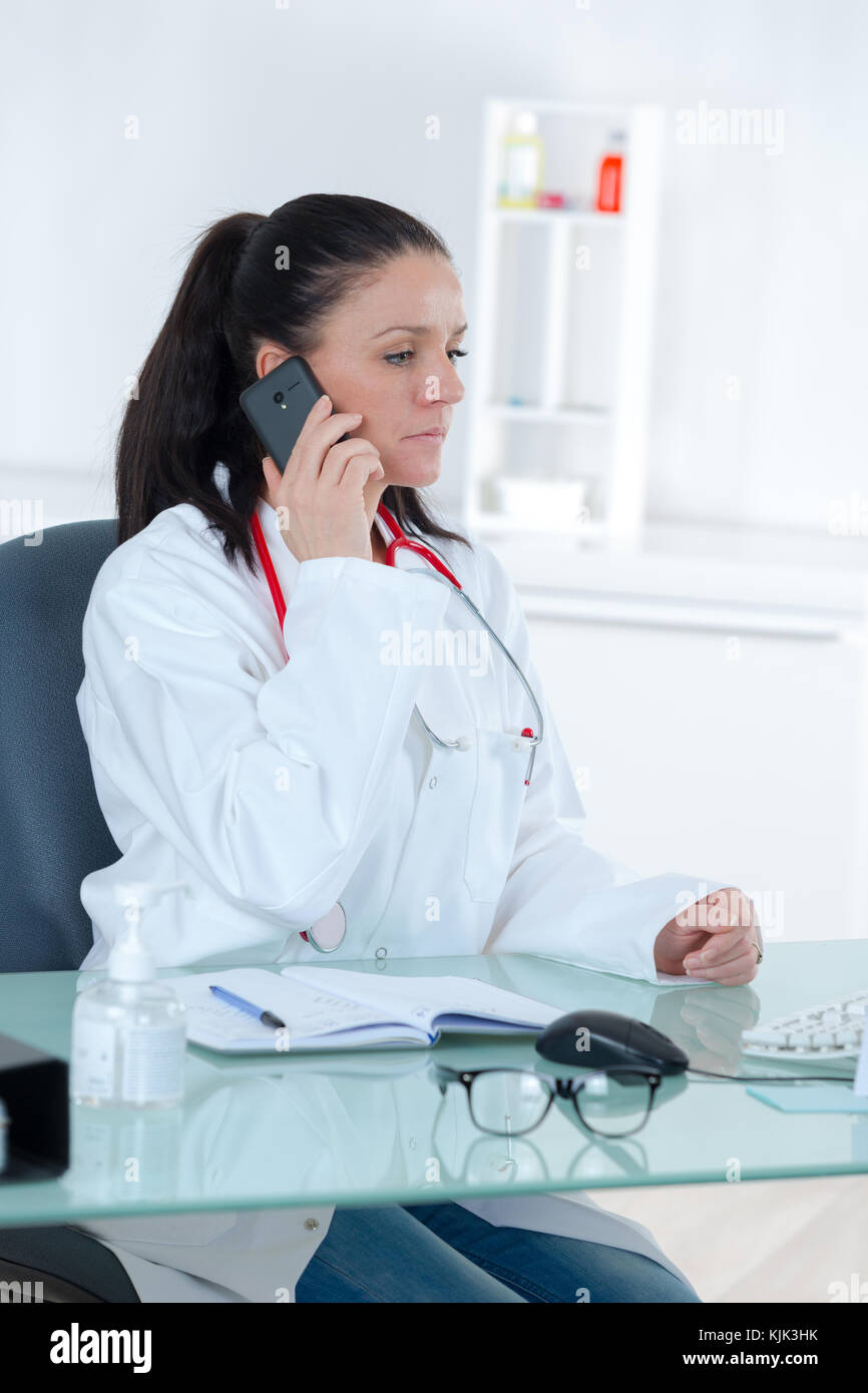 beautiful young female doctor sitting at the desk Stock Photo - Alamy