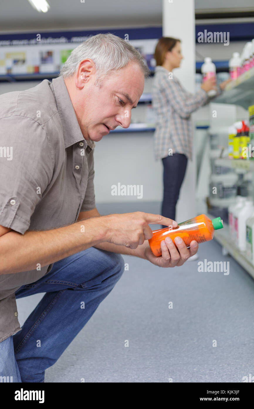 Senior man reading the label on a product Stock Photo - Alamy