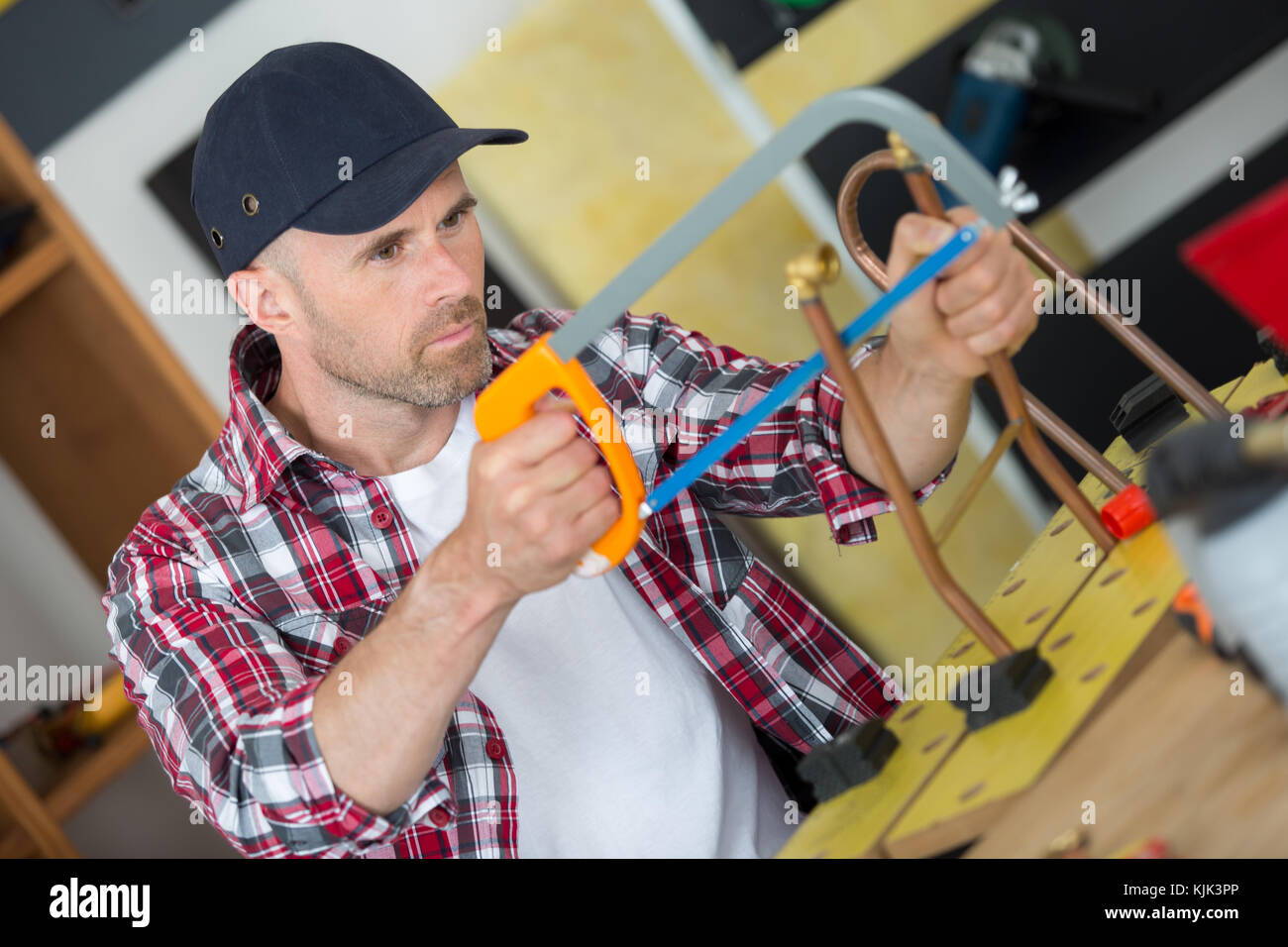 Tradesman using hacksaw Stock Photo - Alamy