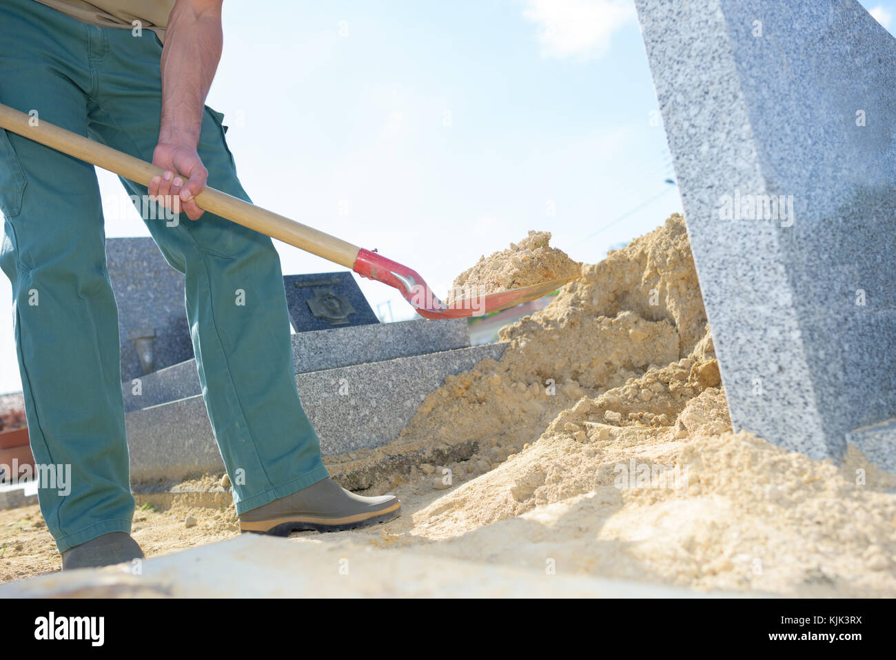 man shovelling sand in graveyard Stock Photo - Alamy