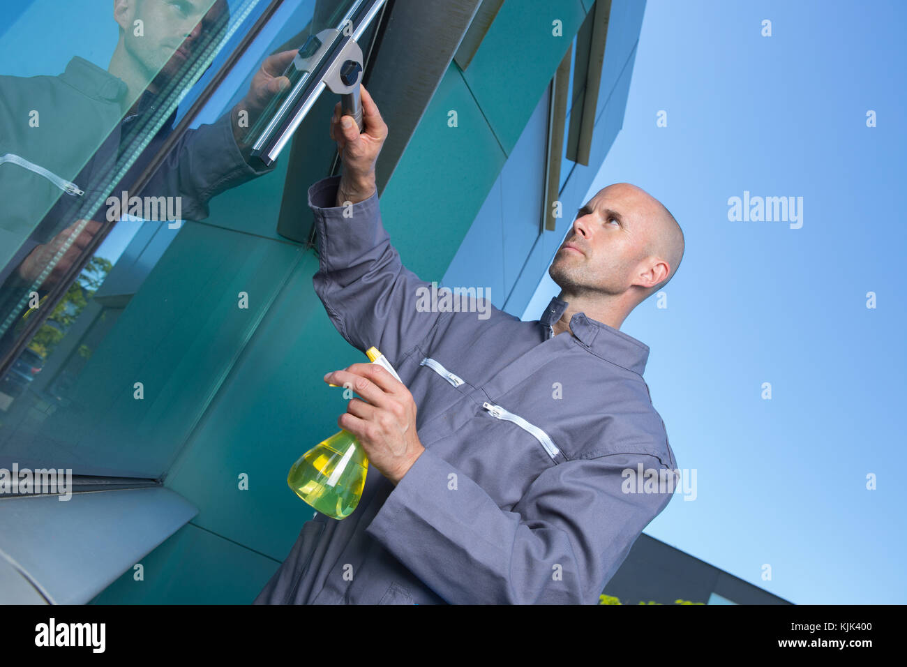 male worker cleaning glass with rag Stock Photo - Alamy