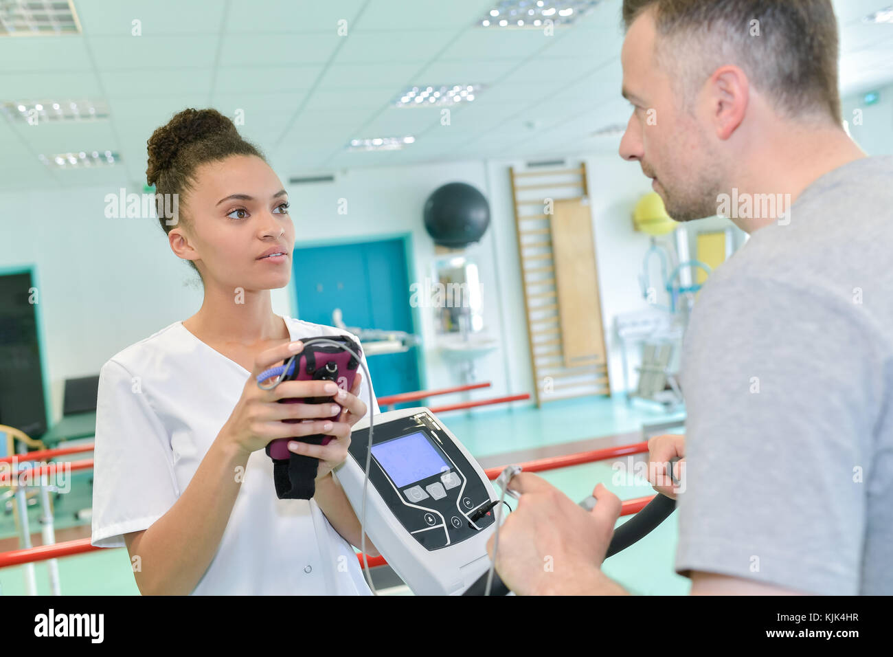 Nurse with patient on exercise machine Stock Photo - Alamy