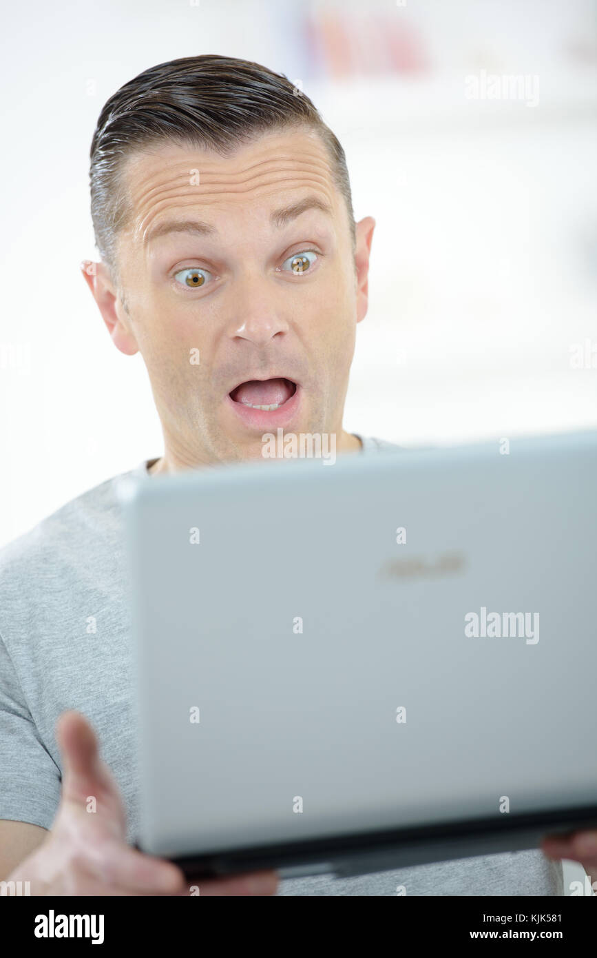 surprised man looking at computer screen Stock Photo - Alamy