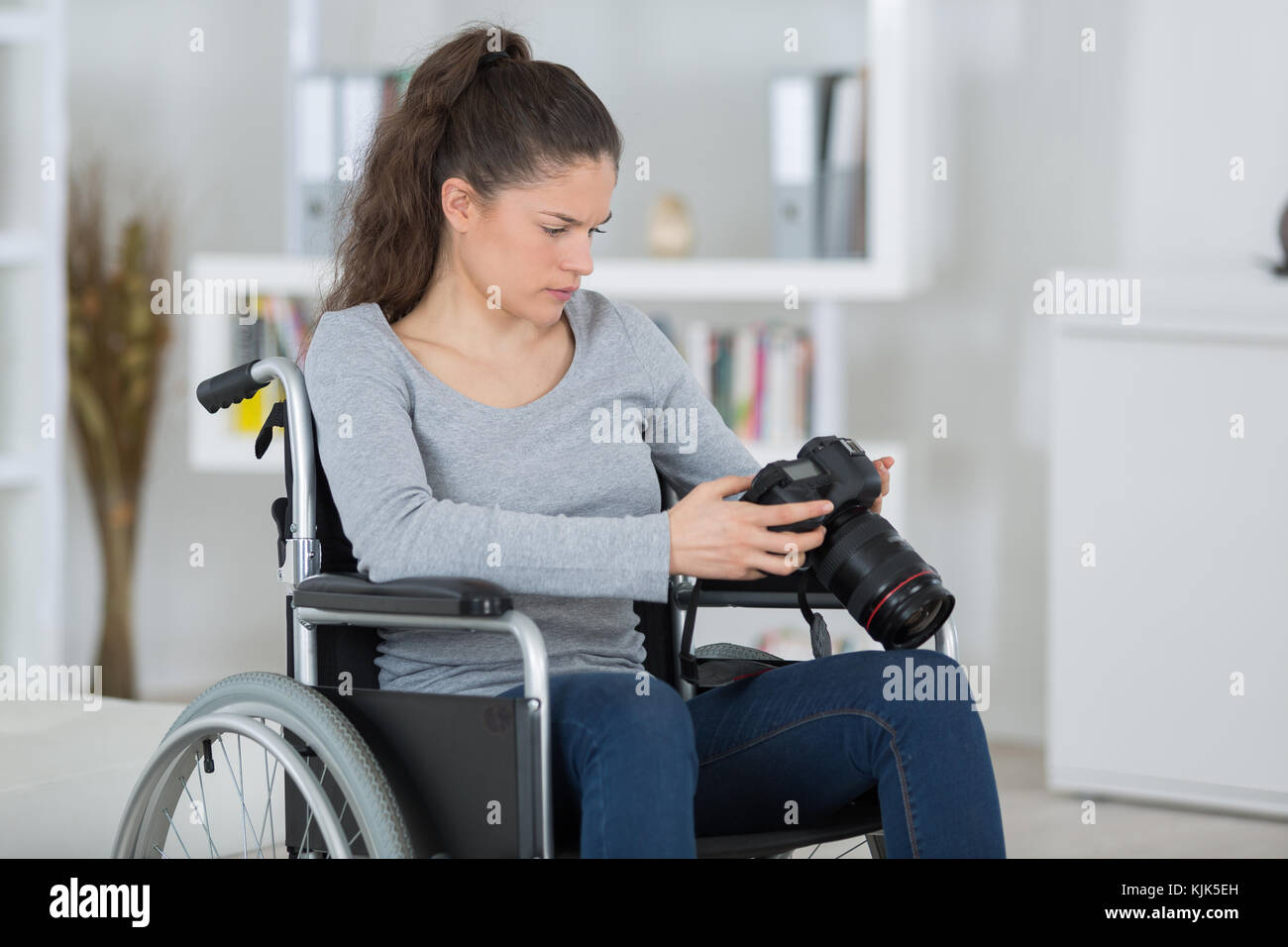 female photographer in a wheelchair holding a professional camera Stock ...