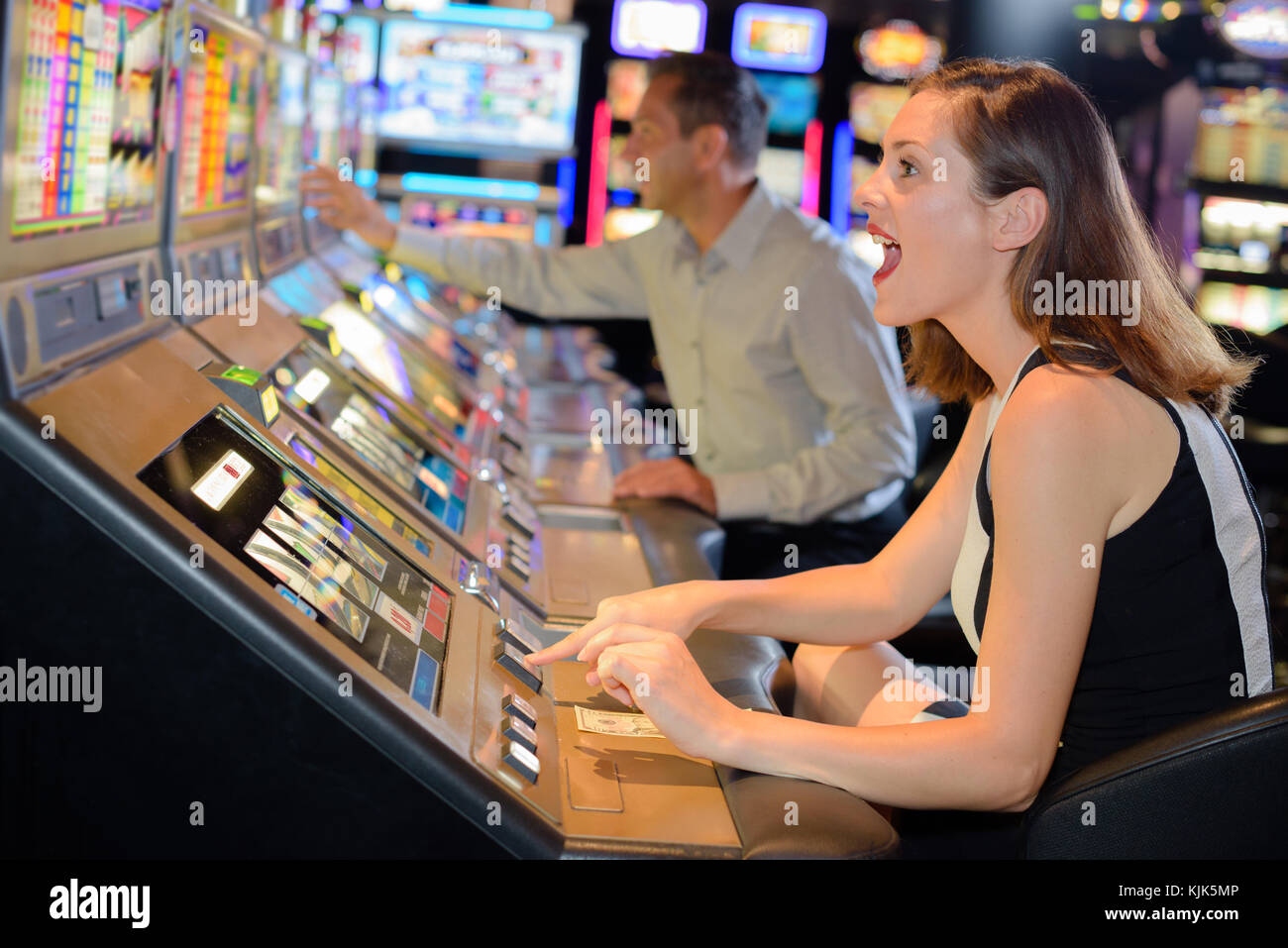 Woman cheering encouragement to arcade machine Stock Photo - Alamy