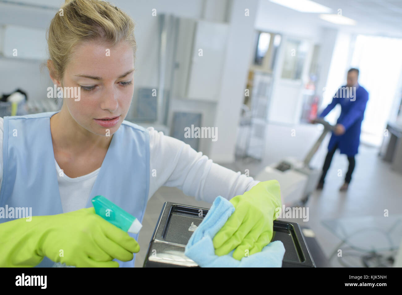 professional female cleaner cleaning furniture at office with sprayer ...