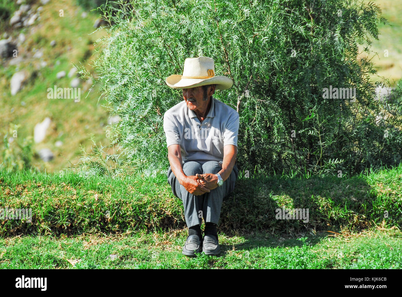 AREQUIPA, PERU - AUGUST 11, 2006: Peruvian farmer sitting along the ...