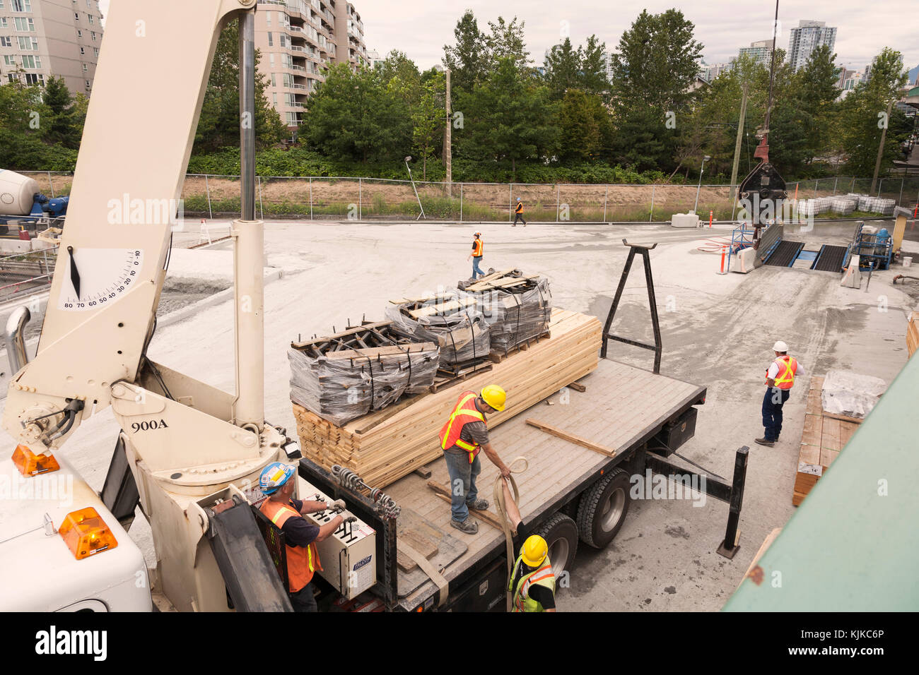 Construction workers hoisting materials Stock Photo - Alamy