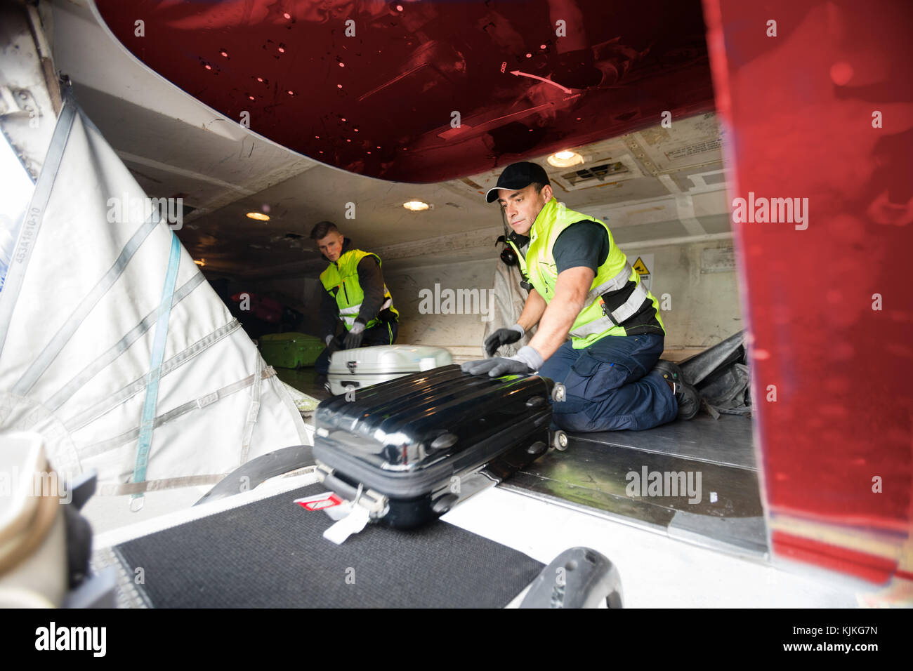 Male workers loading luggage in airplane at airport Stock Photo - Alamy