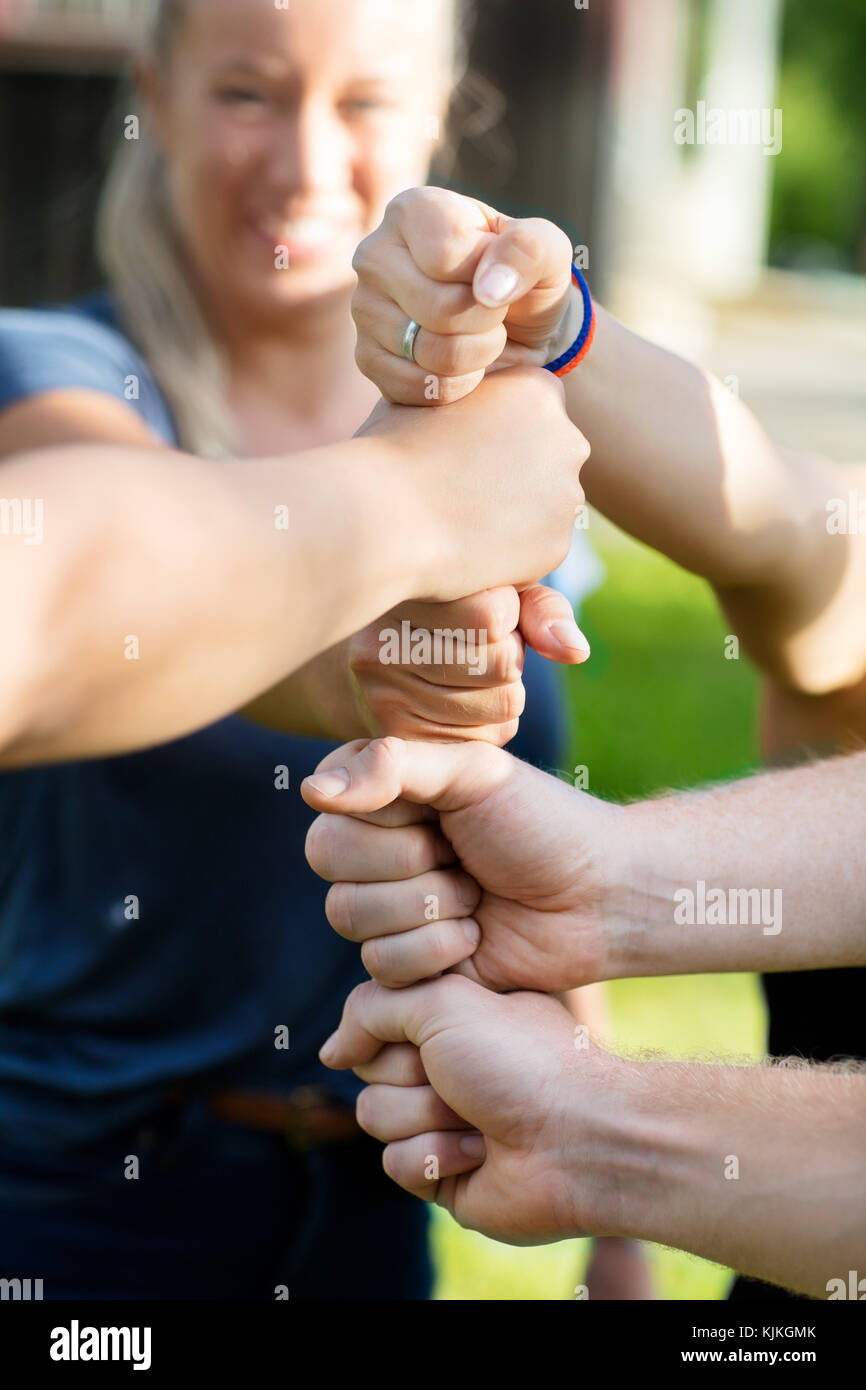Cropped image of friends stacking fists in forest Stock Photo - Alamy