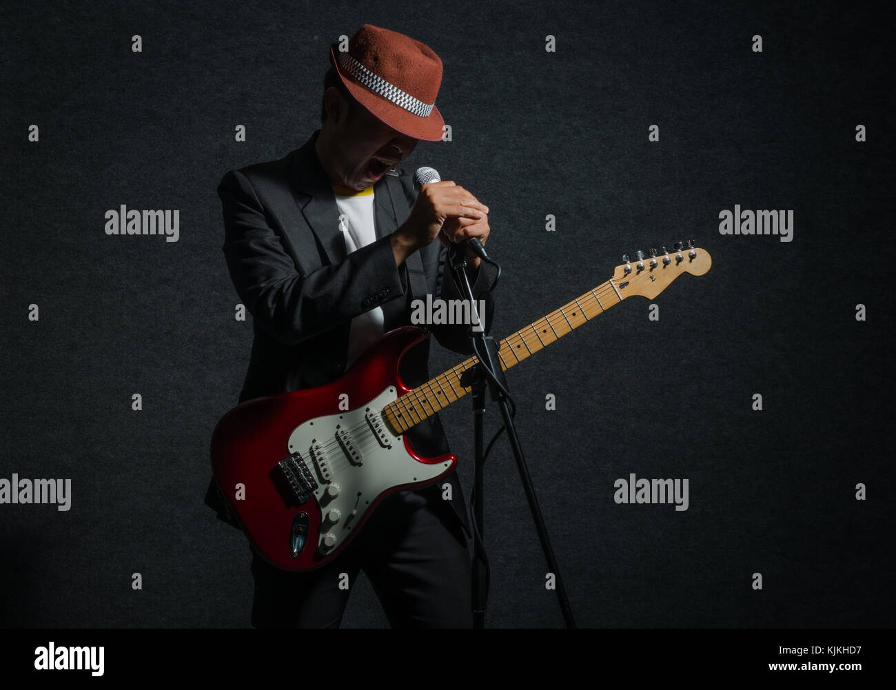 Musician playing the guitar with hand holding the microphone and ...