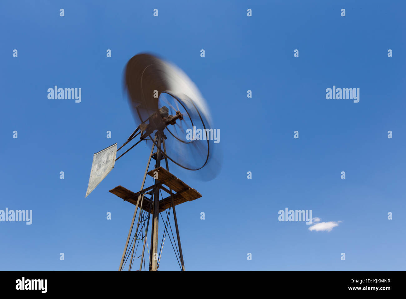 Close up wide angle image of a windmill / windpomp with spinning blades ...