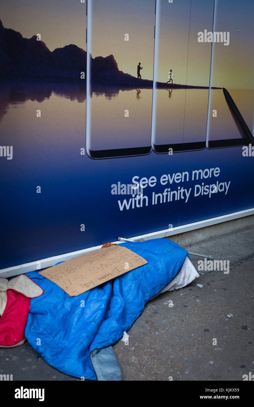 The possessions of a homeless person beneath an aspirational ad for ...