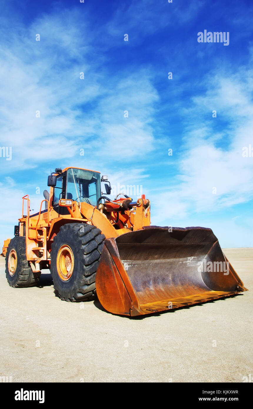Orange loader bulldozer with cloud sky Stock Photo - Alamy