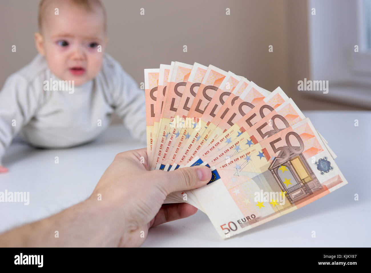 Crying baby looking at a pile of money Stock Photo - Alamy