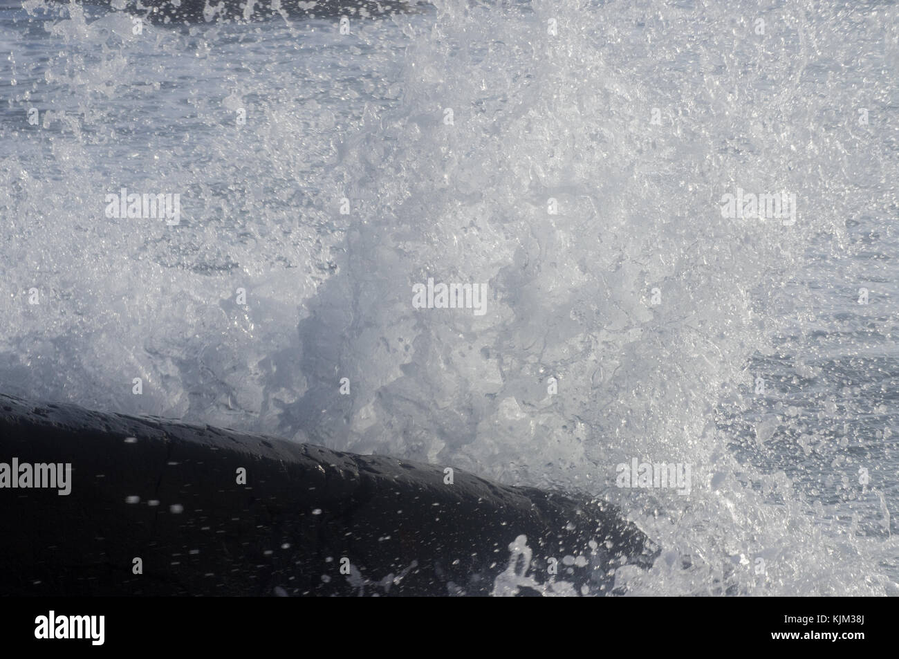 Many drops of water from a storm wave in the sea beats against a huge ...