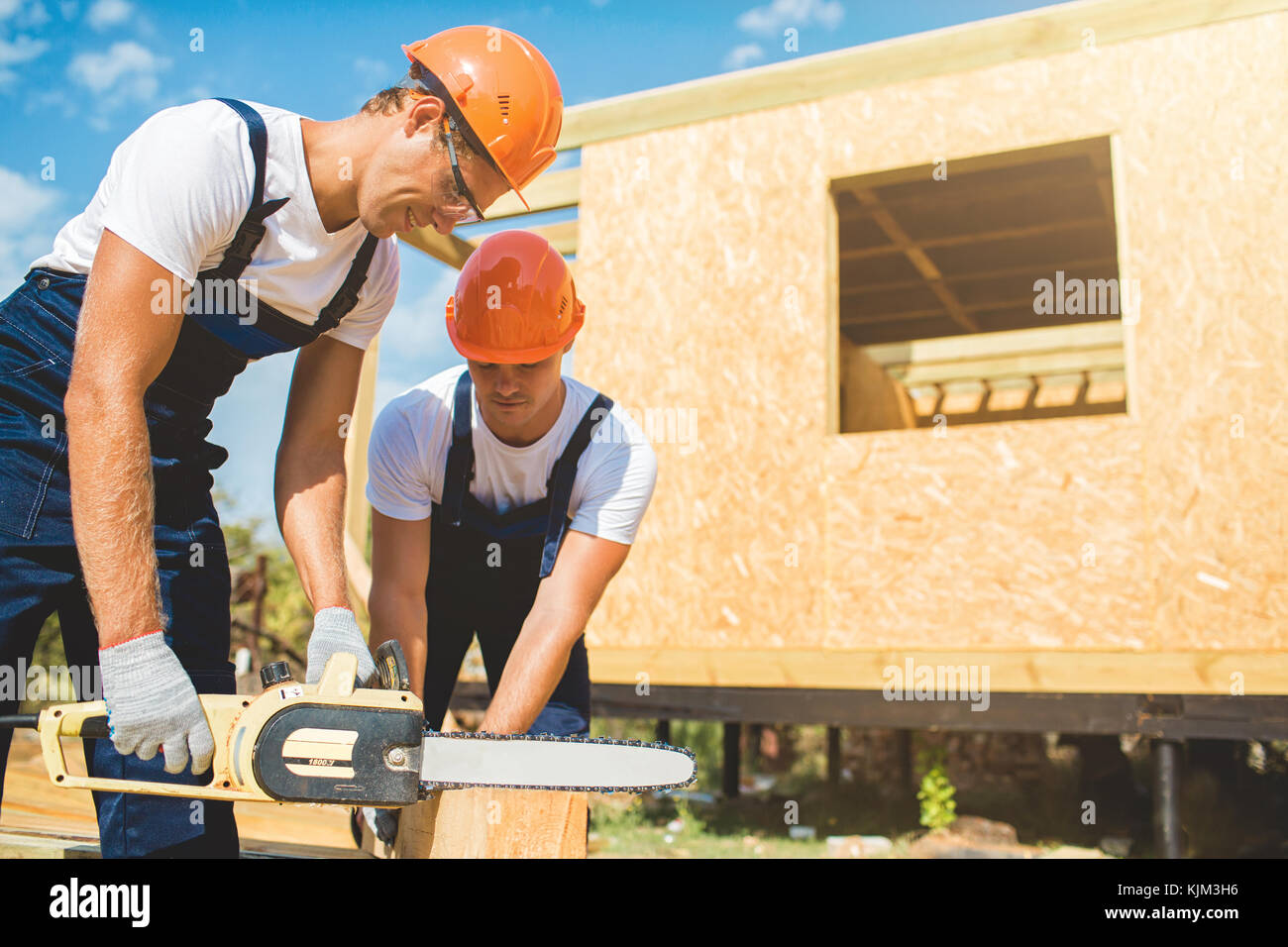 Two young man building wooden house. Ecology concept Stock Photo - Alamy