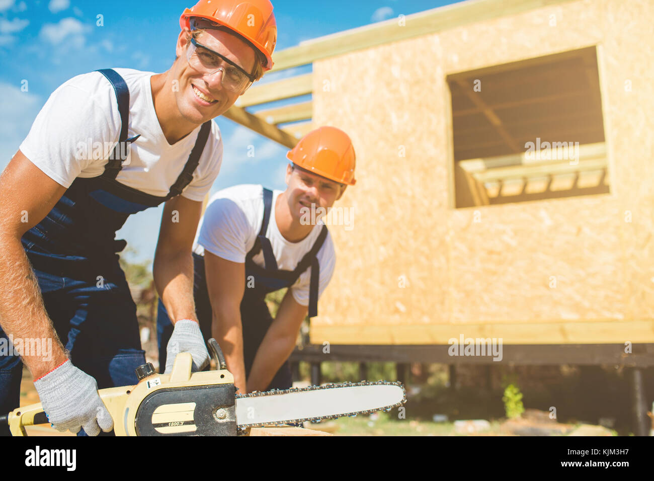 Two young man building wooden house. Ecology concept Stock Photo - Alamy