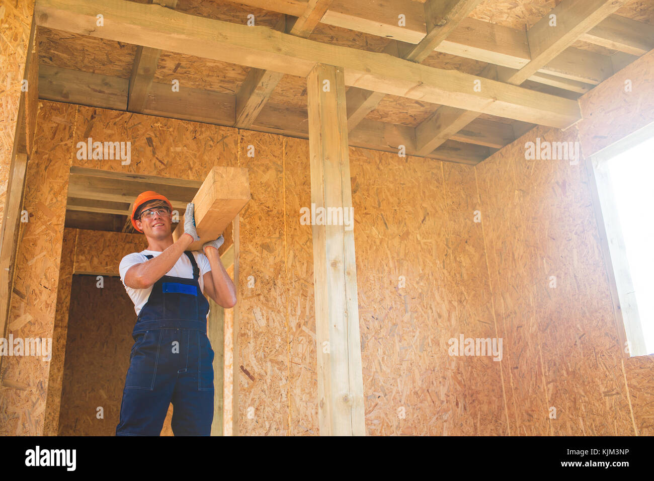 Young man building wooden house. Ecology concept Stock Photo - Alamy