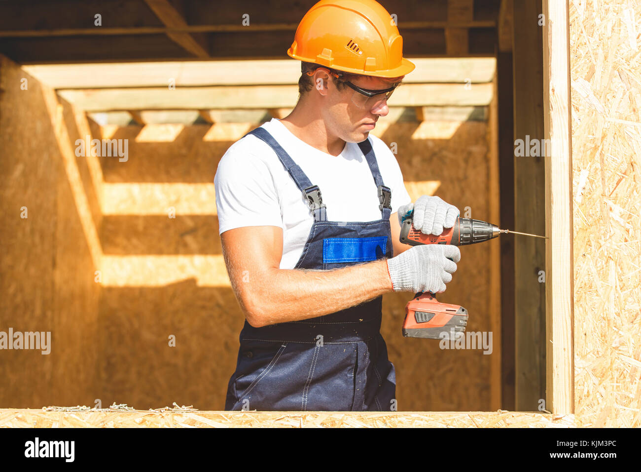 Young man building wooden house. Ecology concept Stock Photo - Alamy