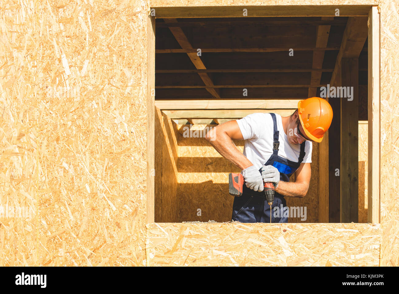 Young man building wooden house. Ecology concept Stock Photo - Alamy