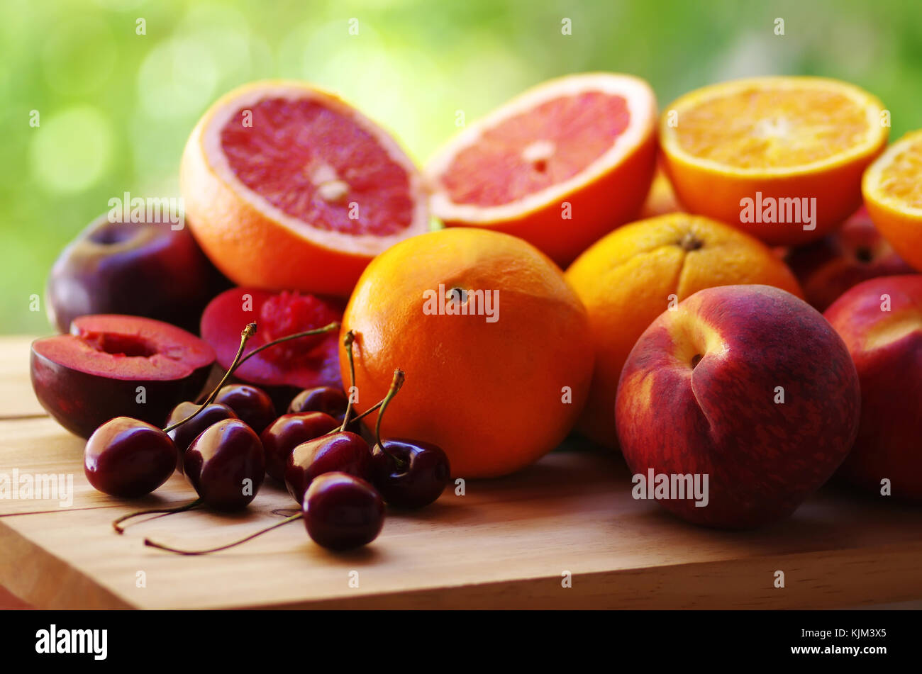 cherry, peaches and citric fruits on table Stock Photo - Alamy