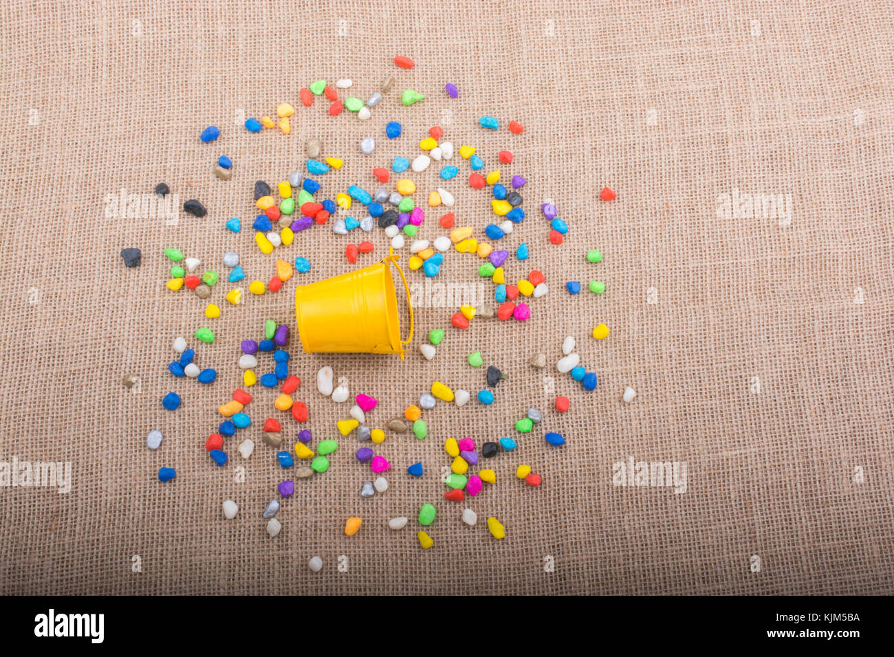 Bucket of colorful pebbles spill on background Stock Photo - Alamy