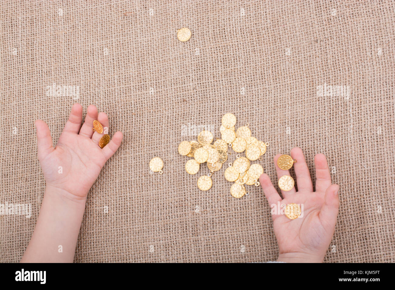 Plenty of fake gold coins in hand on canvas Stock Photo - Alamy